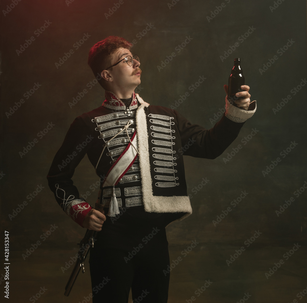 Young man in suit as royal person isolated on dark green background ...