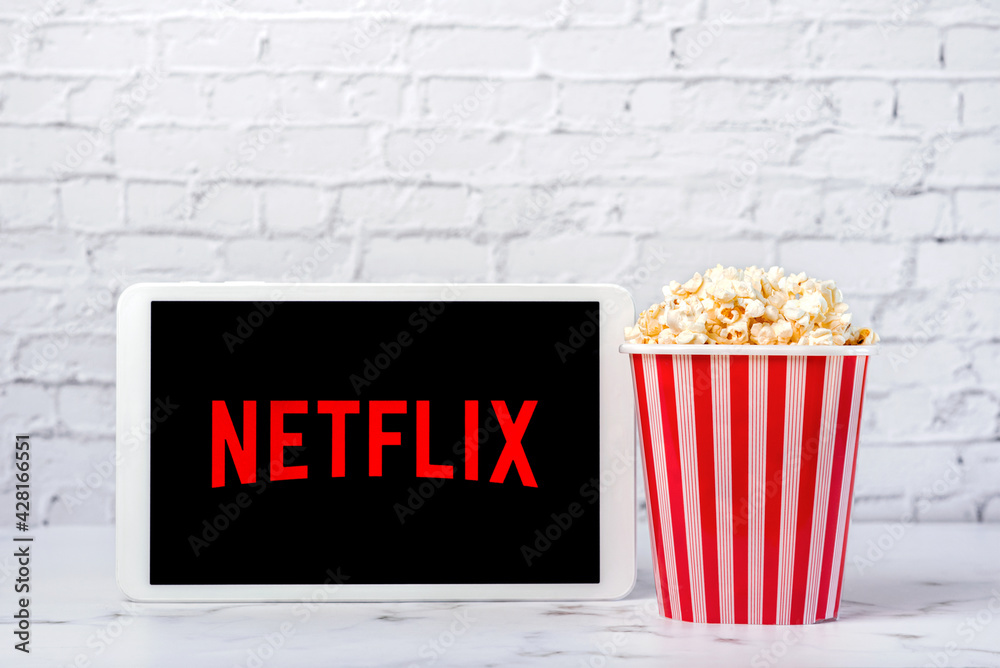 Netflix logo on the screen of a white digital tablet with popcorn Stock ...