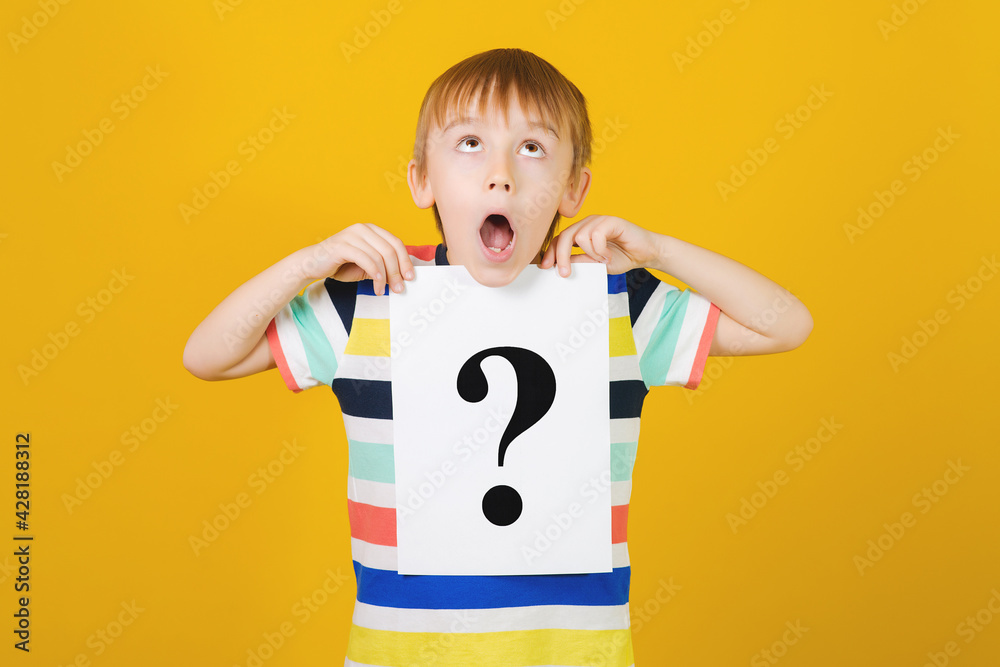 Cute thoughtful boy with question mark. Schoolboy shows question mark ...