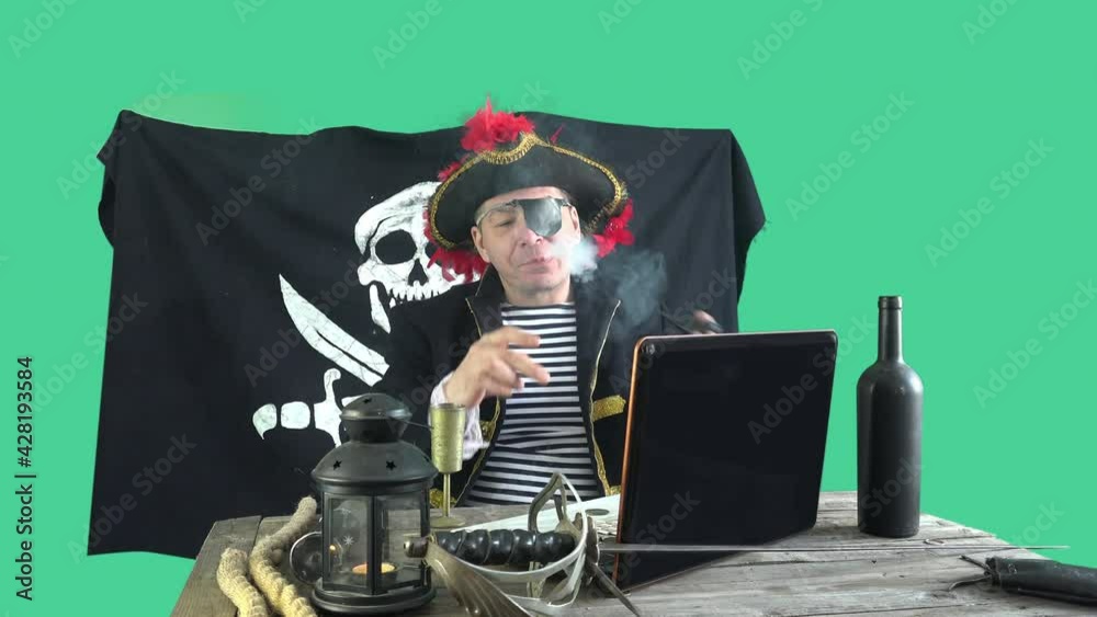 Happy one-eyed pirate hacker in triangular hat smokes pipe and types on ...