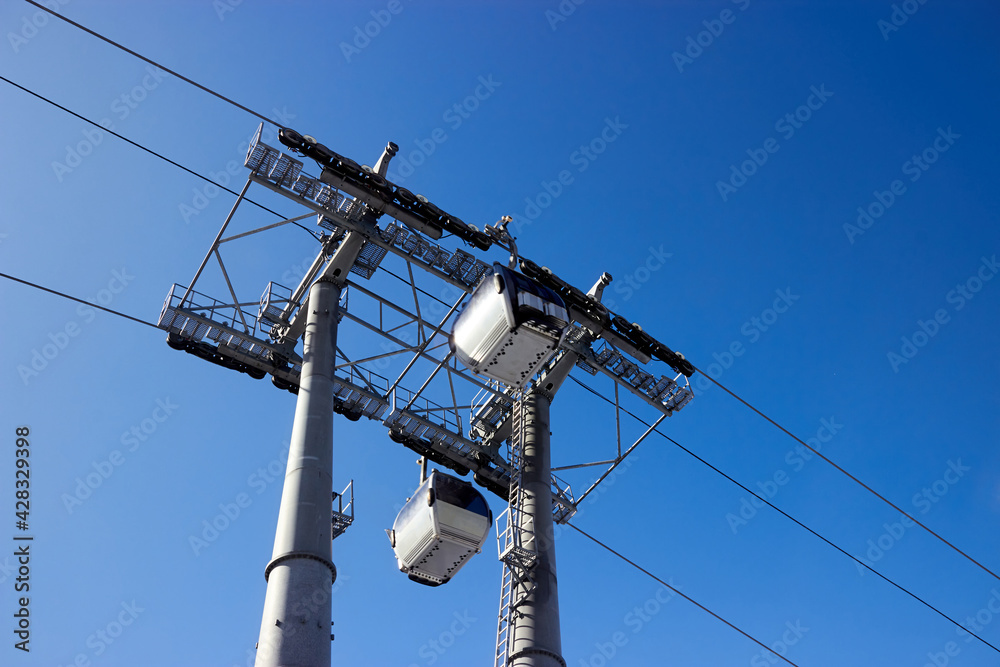 cableway cabin and cable support tower in a ski resort against the blue ...