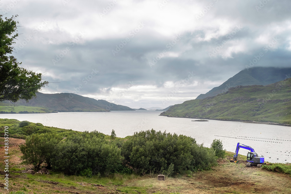 Light blue color excavator working on a ground. Beautiful nature ...