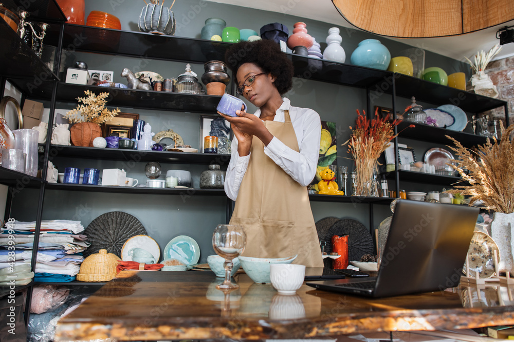 Experienced african saleswoman doing inventory at modern store with ...