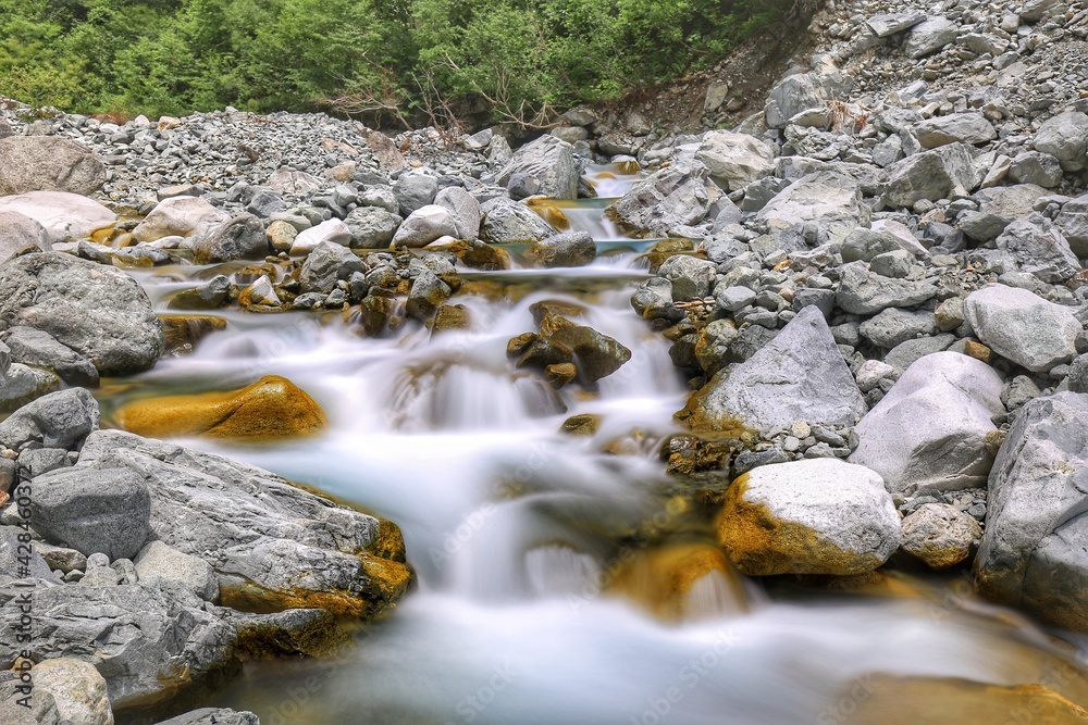fluffy soft water flow over the stone running in the river near by ...