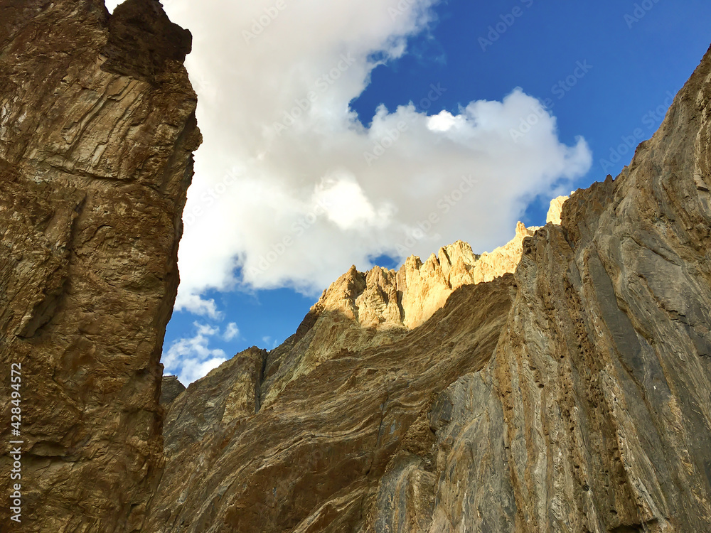 Fotografia do Stock: Low angle shot of jagged cliffs against a cloudy ...