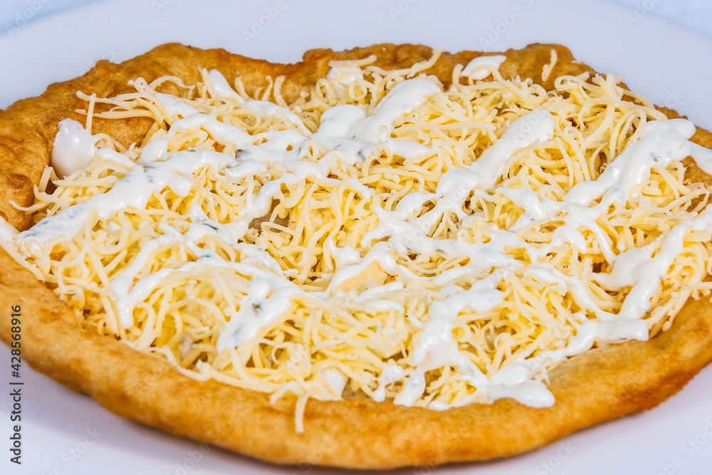 Langos stuffed with grated cheese and dressing.Langos is a traditional ...
