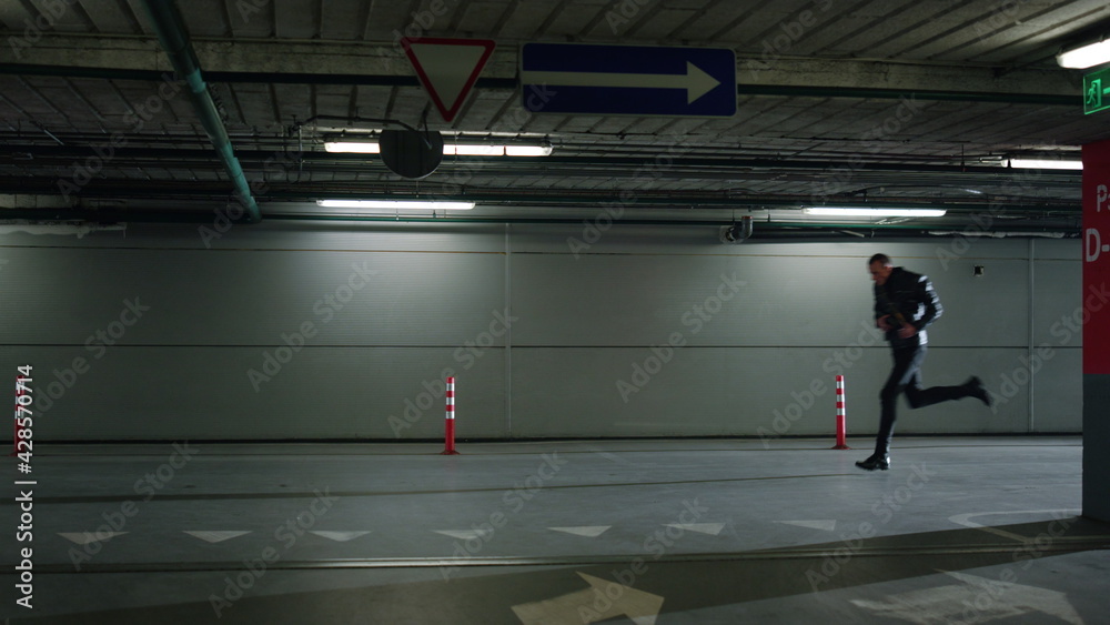 Male criminal running in urban building. Police car with cops following ...