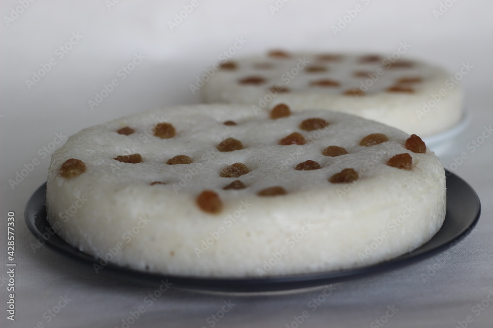 Spongy steamed rice cakes prepared with a fermented batter of rice and ...