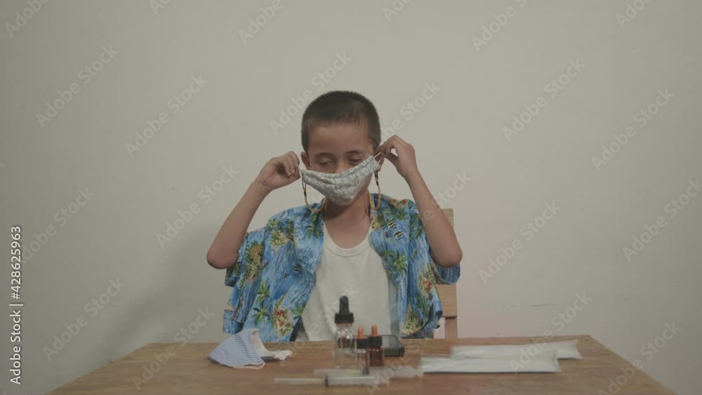 .A cute boy wearing an anti virus protection mask to prevent others ...