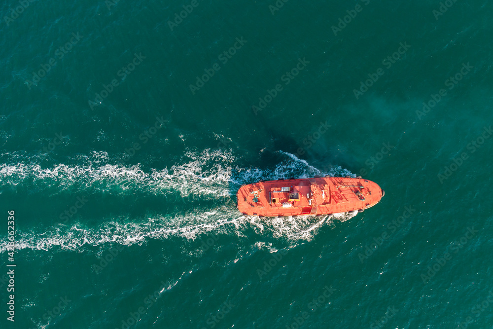 The pilot boat orange goes to meet the vessel on the outer roads ...