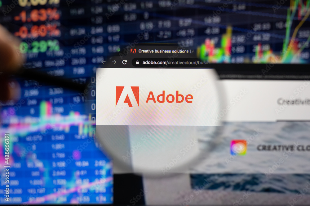 Adobe company logo on a website with blurry stock market developments ...
