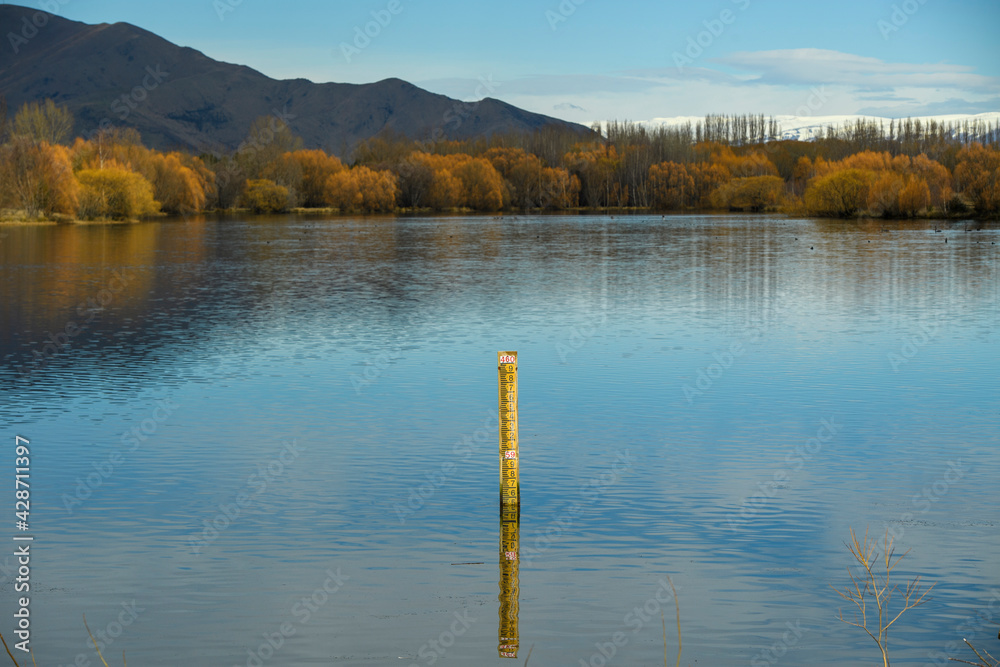 Water level measuring pole The background is mountains and trees in the ...