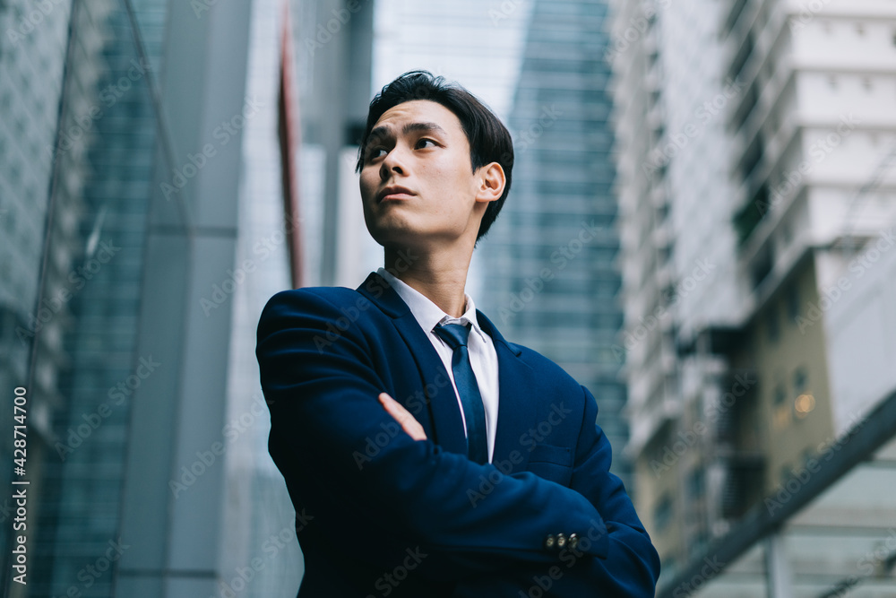 Image of Young asian businessman with glass building background Stock ...