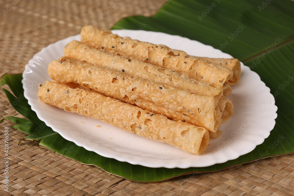 Indian fried snack Kuzhalappam Kerala fried snacks food on banana leaf ...