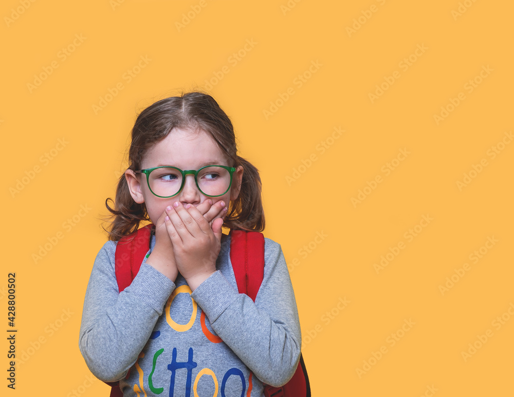 Cute little girl covering mouth with hands. Showing intense expression ...
