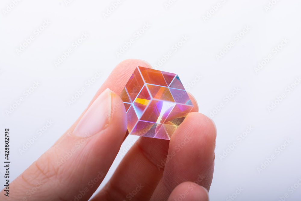 Optical glass cube in hand Light dispersion,spectrum. Physics optics ...