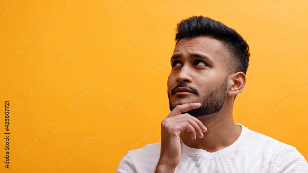 Portrait of handsome adult man touching his chin an looking up. Mixed ...