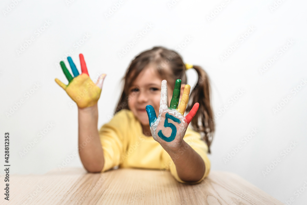 Happy toothless little girl with the five number painted on the hand ...
