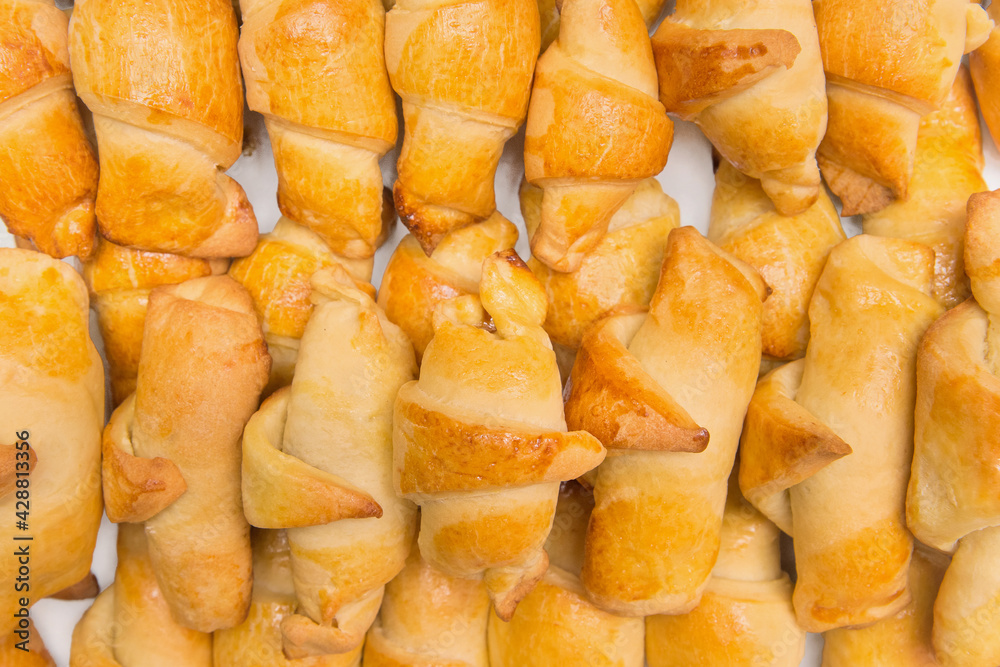 Fresh homemade baked goods. Croissants in heap background. Buns on the ...