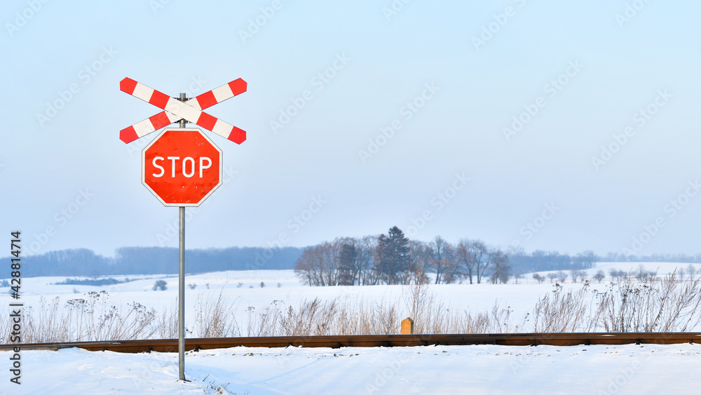 Red stop sign and St. Andrew's cross in front of an unguarded railway ...