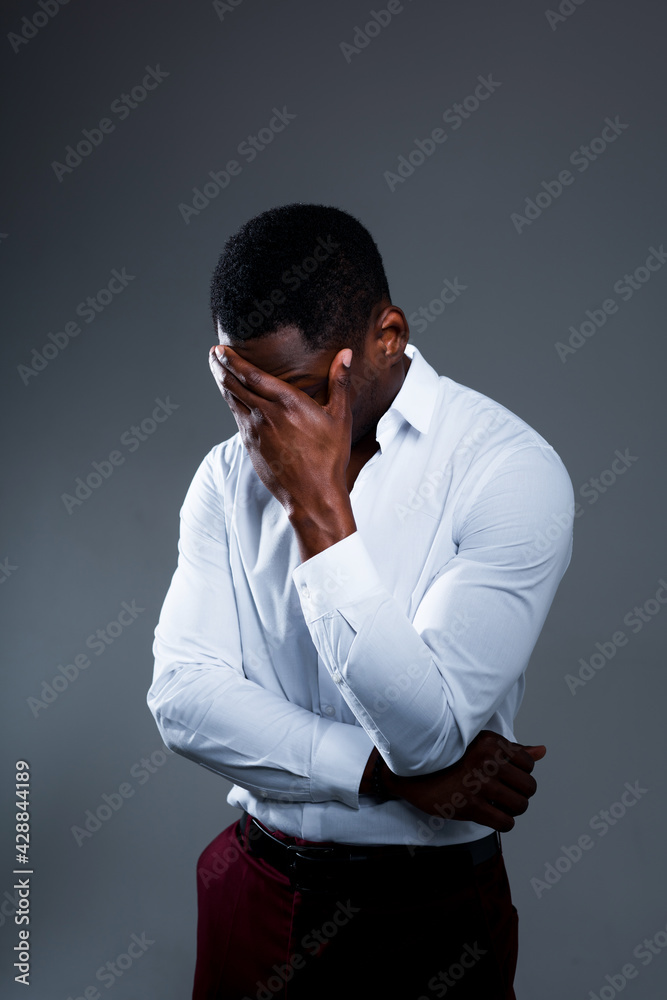 Foto de Tired African American man covers his face with his hand ...