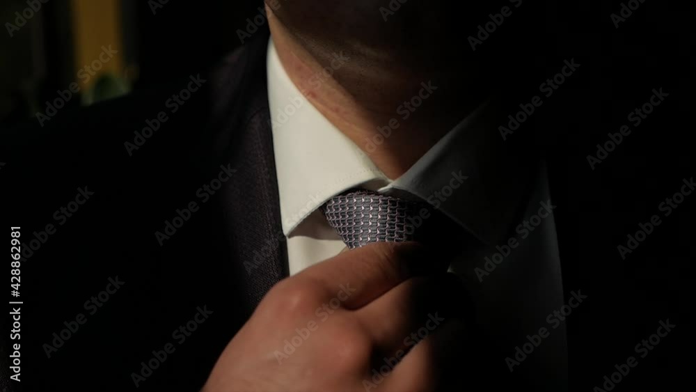businessman adjusting tie.a man in a suit straightens his tie Stock ...