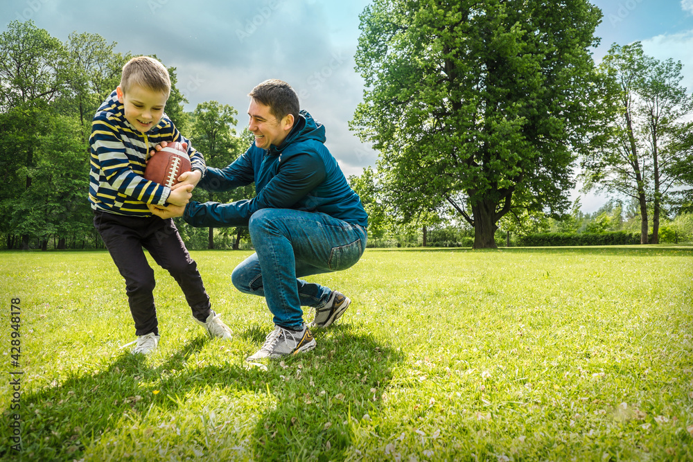 Father and son playing football, Father's day, Playful Man teaching Boy ...