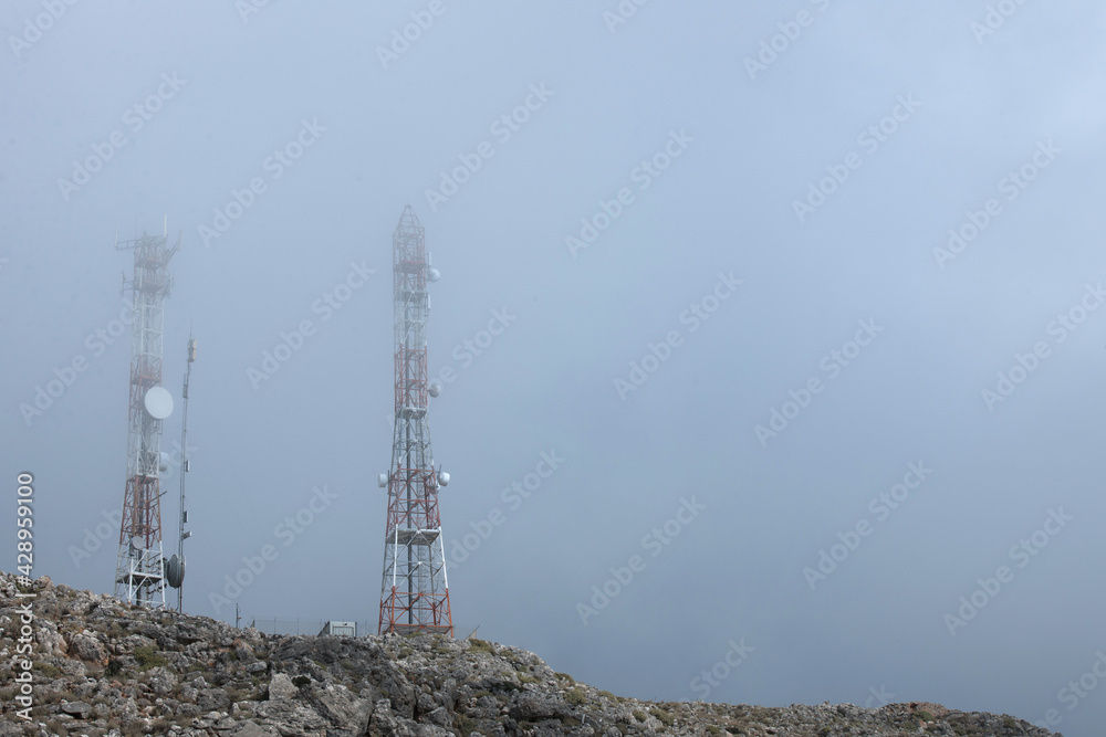 Ground view of telecommunication towers in the clouds on a mountain ...