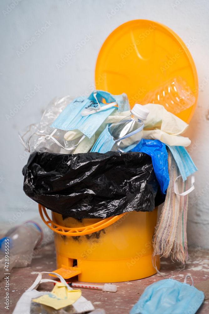 Filed or over flowed single use Medical waste on garbage can or trash ...