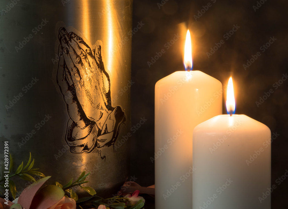 Mortuary urn with burning candles and flowers against dark background ...