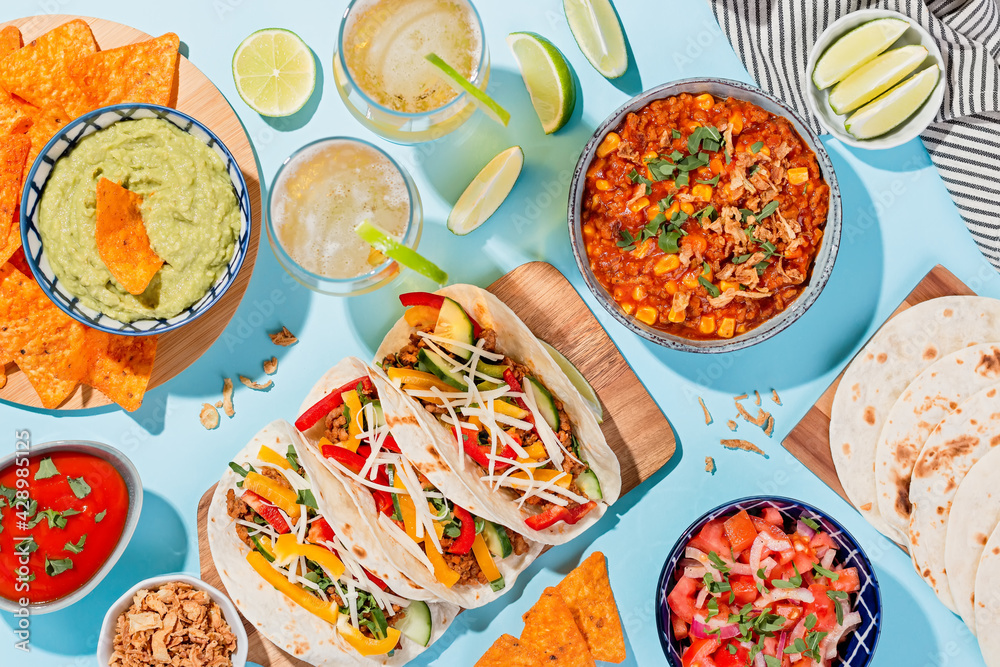 Mexican food table with traditional dishes. Chili con carne, tacos ...