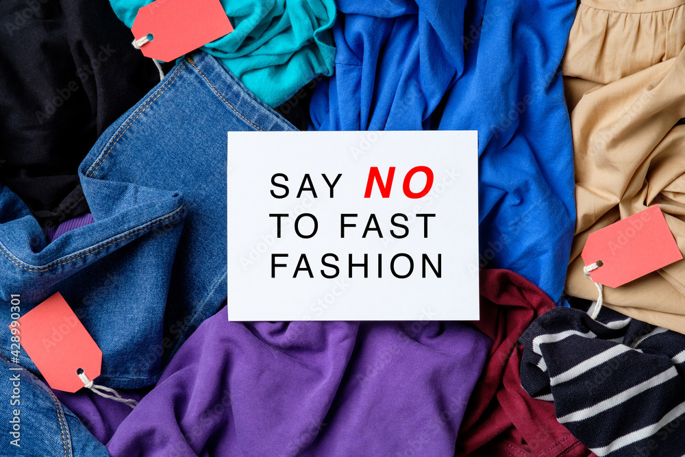 Say No To Fast Fashion sign on paper card over heap of clothes. Fast ...