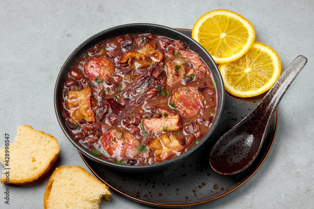 Feijoada in black bowl gray concrete table top. Brazilian and ...