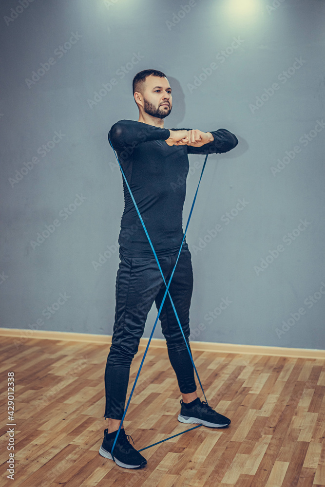 Vertical, full-length sportsman workout with loop band, stretch ...