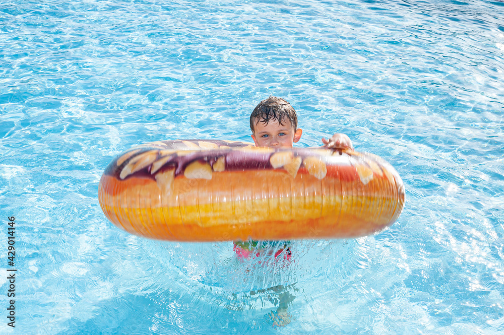 Foto de Little boy relaxing and having fun in swimming pool on summer ...