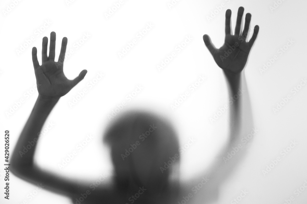 Silhouette scared boy stand behind glass door. Teen problems, negative ...