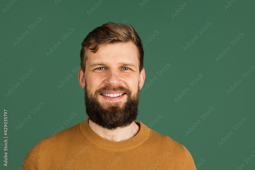 Caucasian man's portrait isolated over green studio background with ...