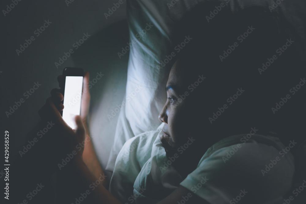 Asian woman playing game on smartphone in the bed at night,Thailand ...