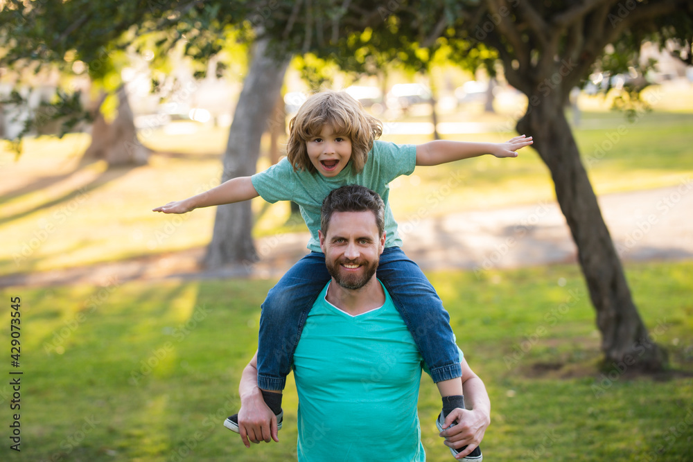 Happy father giving shoulder ride on his shoulders in garden. Son on ...