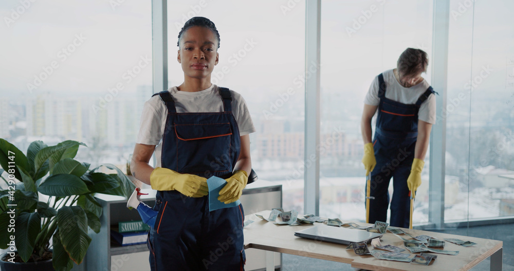 Multi-ethnic cleaning couple disinfecting corporate office. Portrait of ...