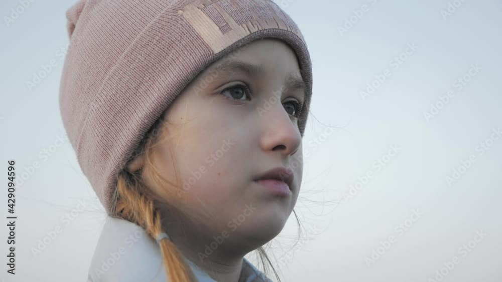 Profile of young girl looking up at sunset sky. Kid wants a dream come ...