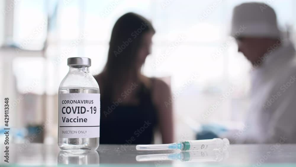 Close-up of a test tube with a coronavirus vaccine dose and a syringe ...
