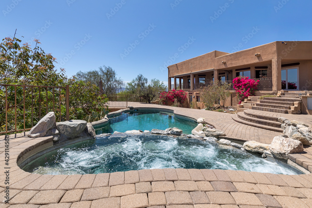 Foto de Swimming pool with hot tub and terraced patio at a luxury home ...