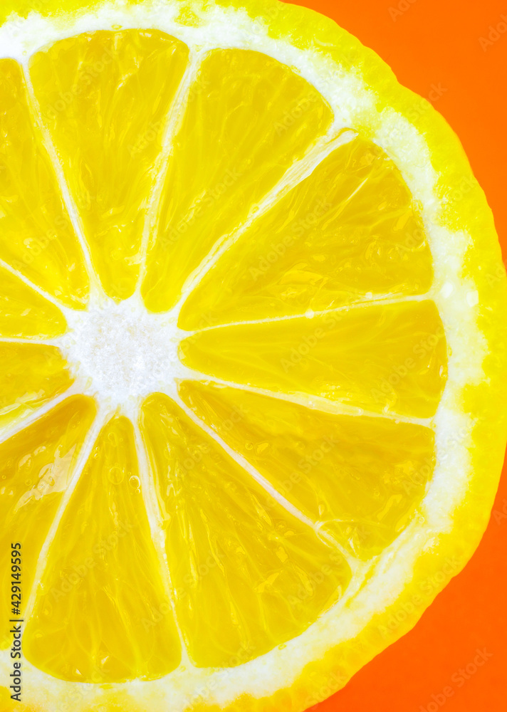 Close up photo of lemon texture on the orange background. Fruit cut in ...