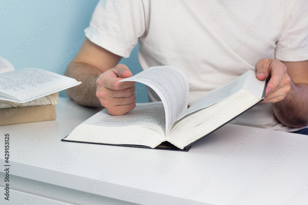 Male hand holding open book in library. Reading club meeting concept ...