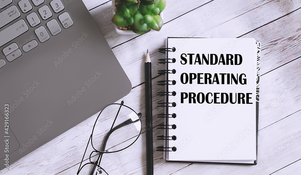 Standard Operating Procedure text on the notebook with office ...