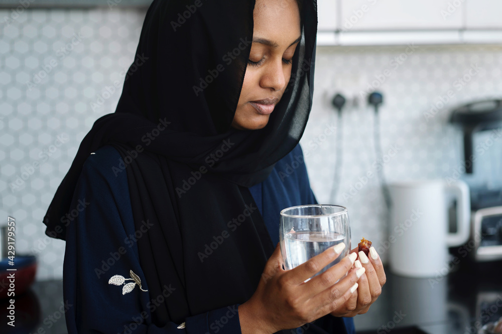 Muslim woman wearing abaya Breaking fast during Ramadan eating dates ...