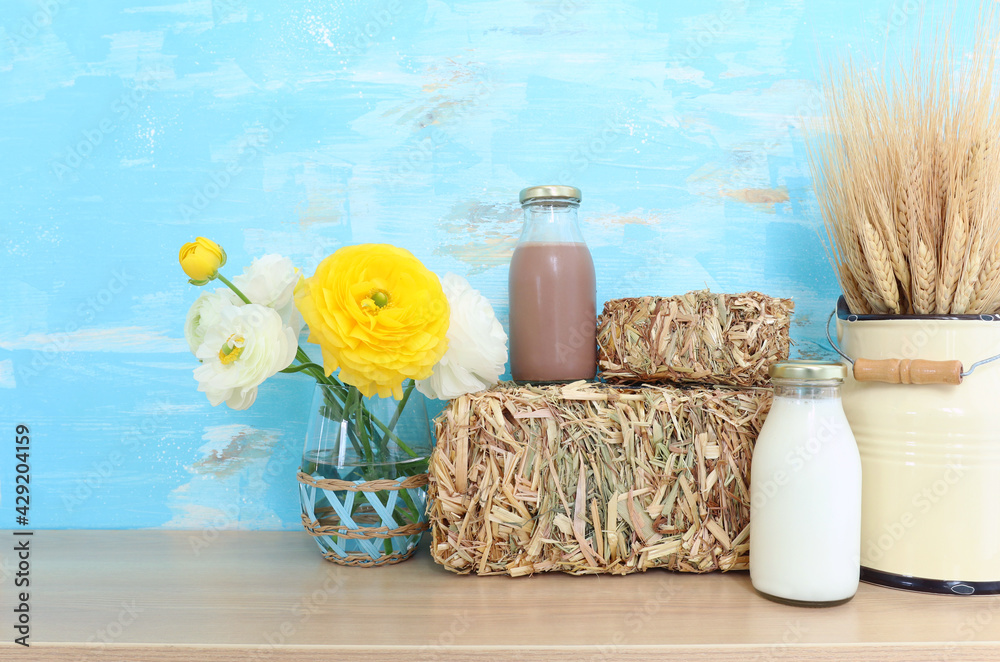 image of dairy products, crops and hay piles over wooden background ...