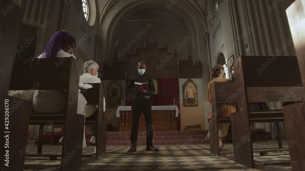 Zoom in of African-American clergyman wearing black clothes, mask and ...