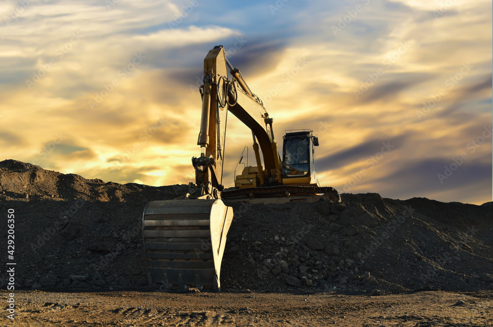 Excavator working on earthmoving at open pit mining on amazing sunset ...
